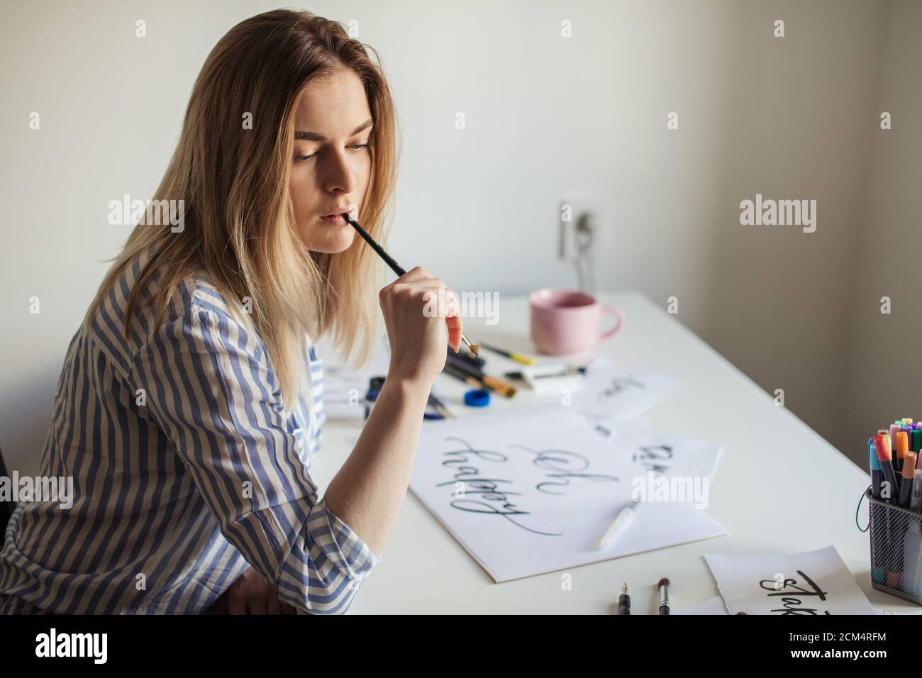 Portrait of female calligraphy artist think about work while sitting at ...