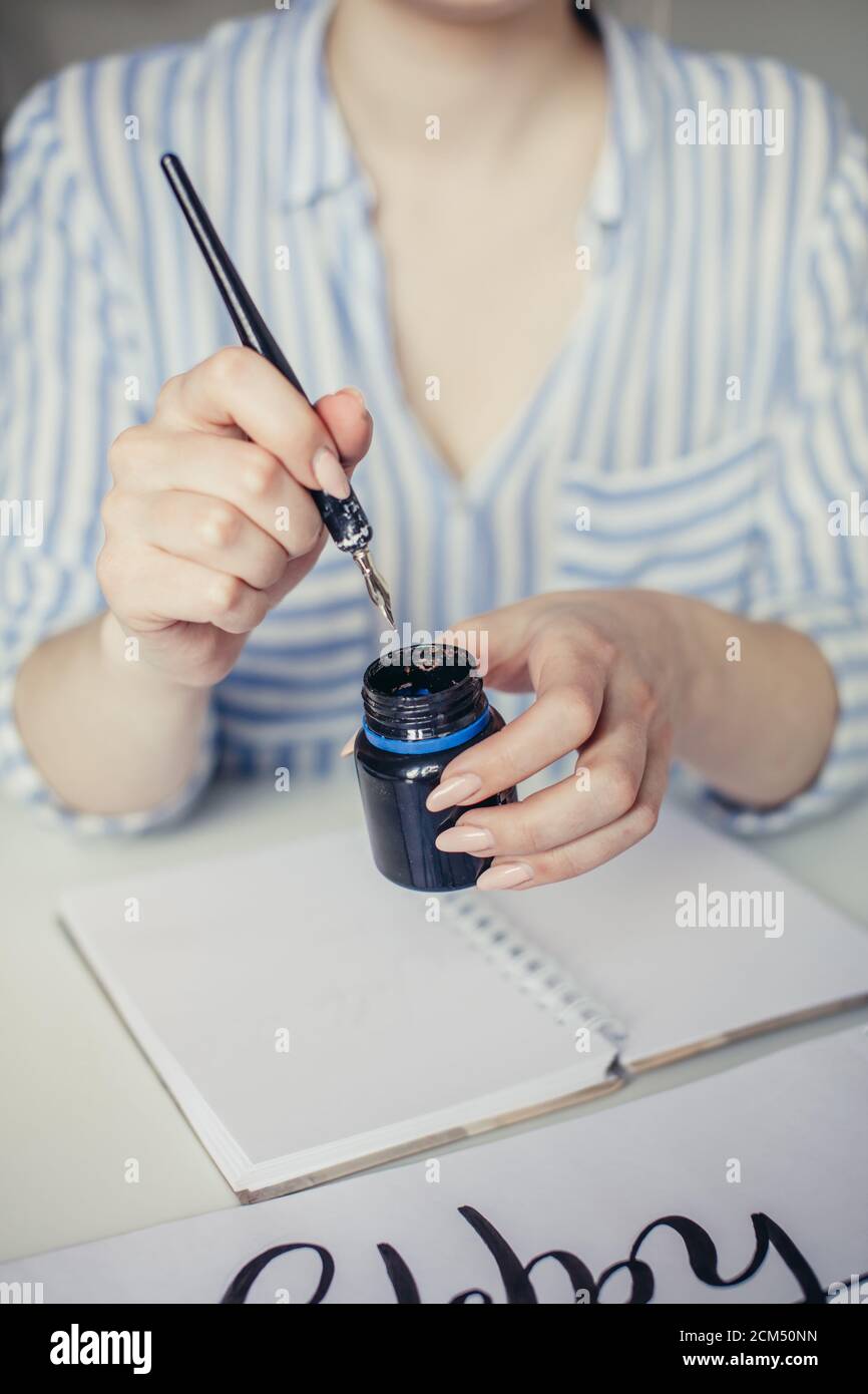 Close up of Female hand dipping calligraphy pen into inkwell Stock ...