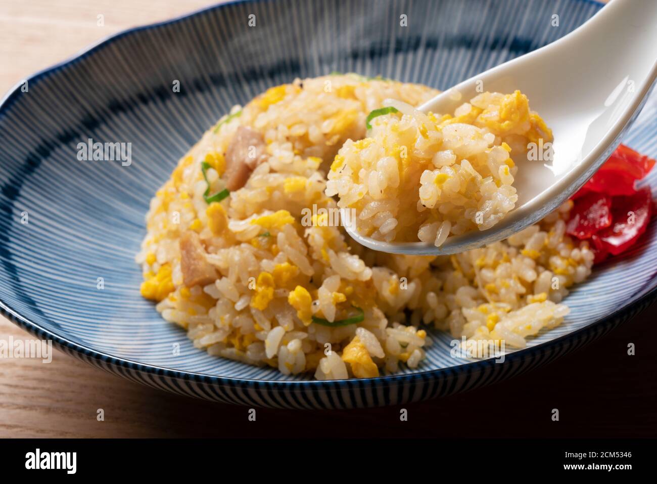 Scoop the fried rice with a Chinese soup spoon Stock Photo - Alamy