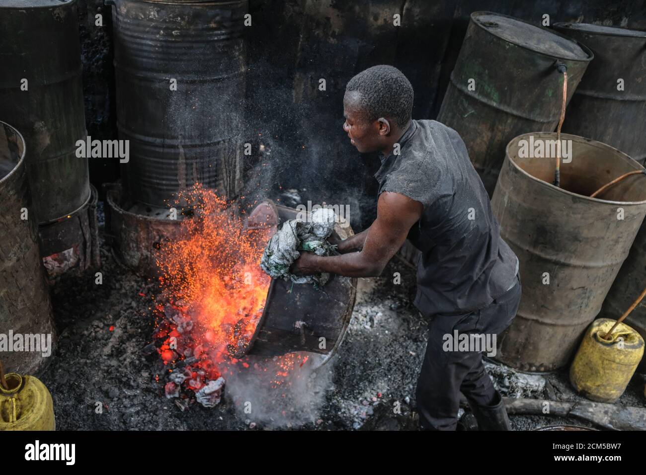 A worker seen putting off fire after preparation of Illicit brew in ...