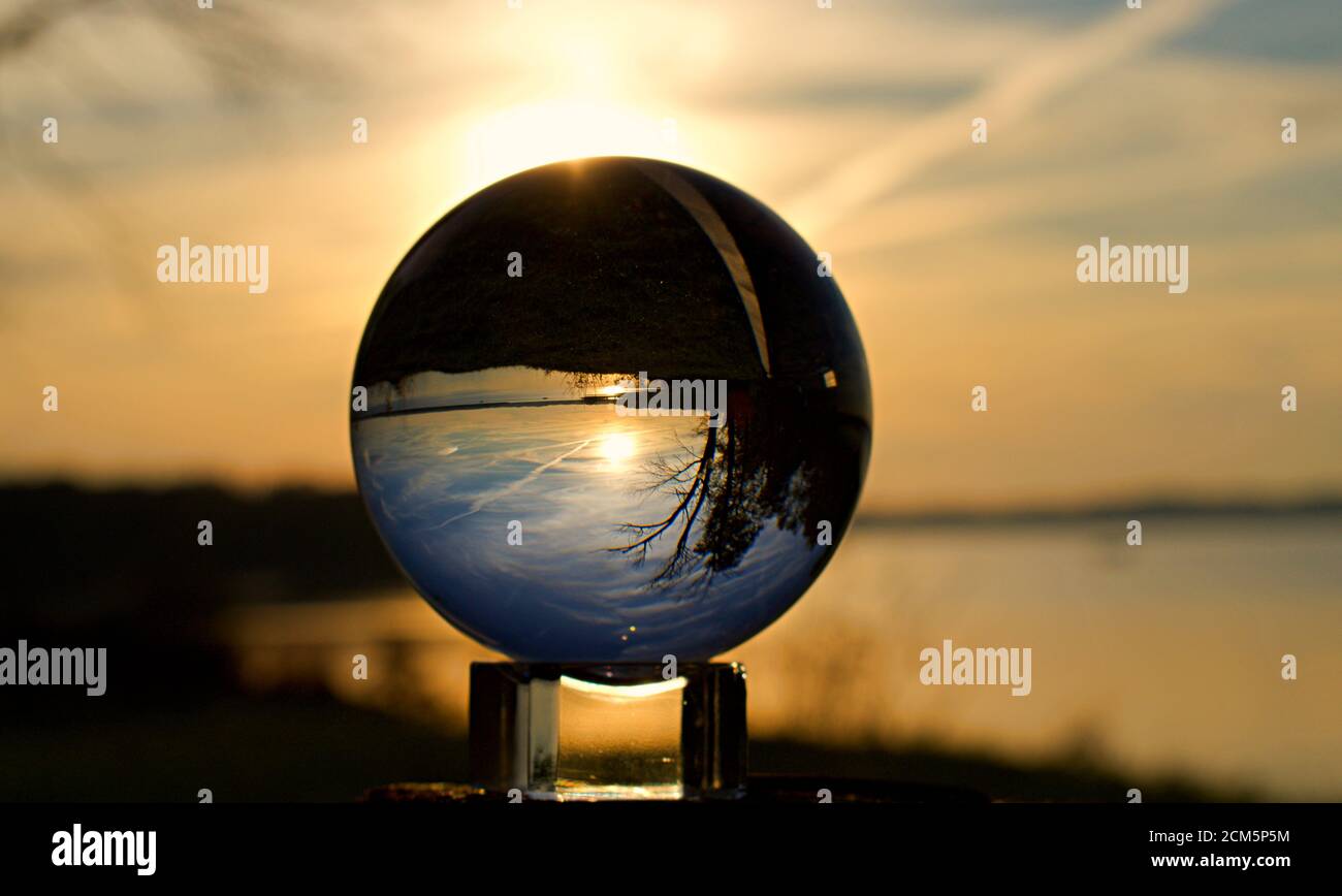 Reflection of sunset over water in a crystal ball Stock Photo - Alamy