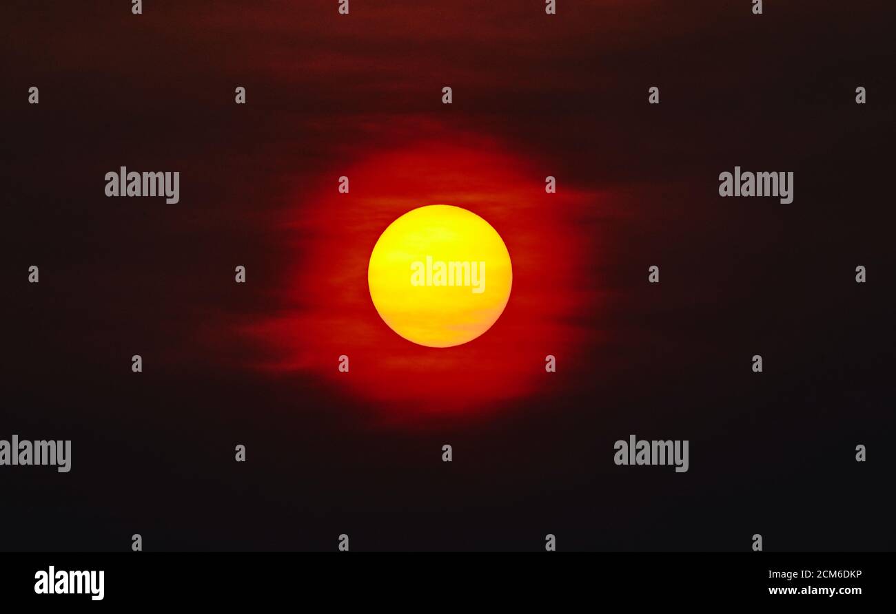 Close up of the sun setting with an overcast sky Stock Photo - Alamy