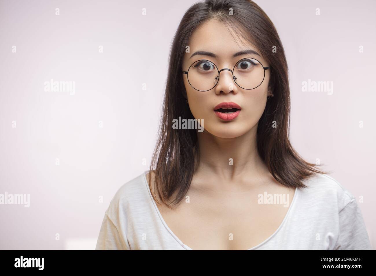 Shocked surprised Asian woman in optical eyewear, looking with ...