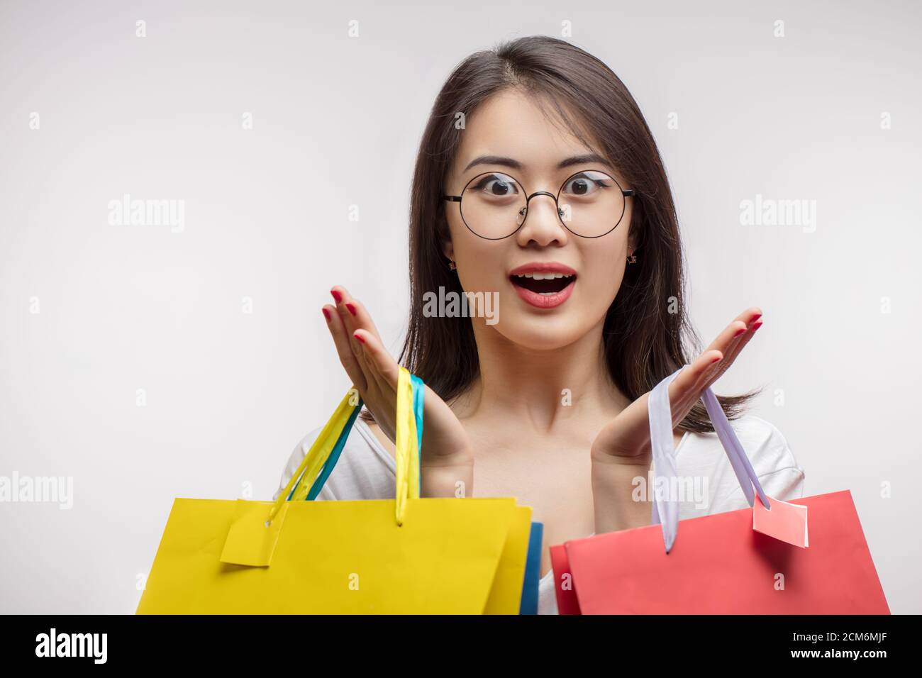Close up of Asian young amazing woman with multi colored shopping bags ...