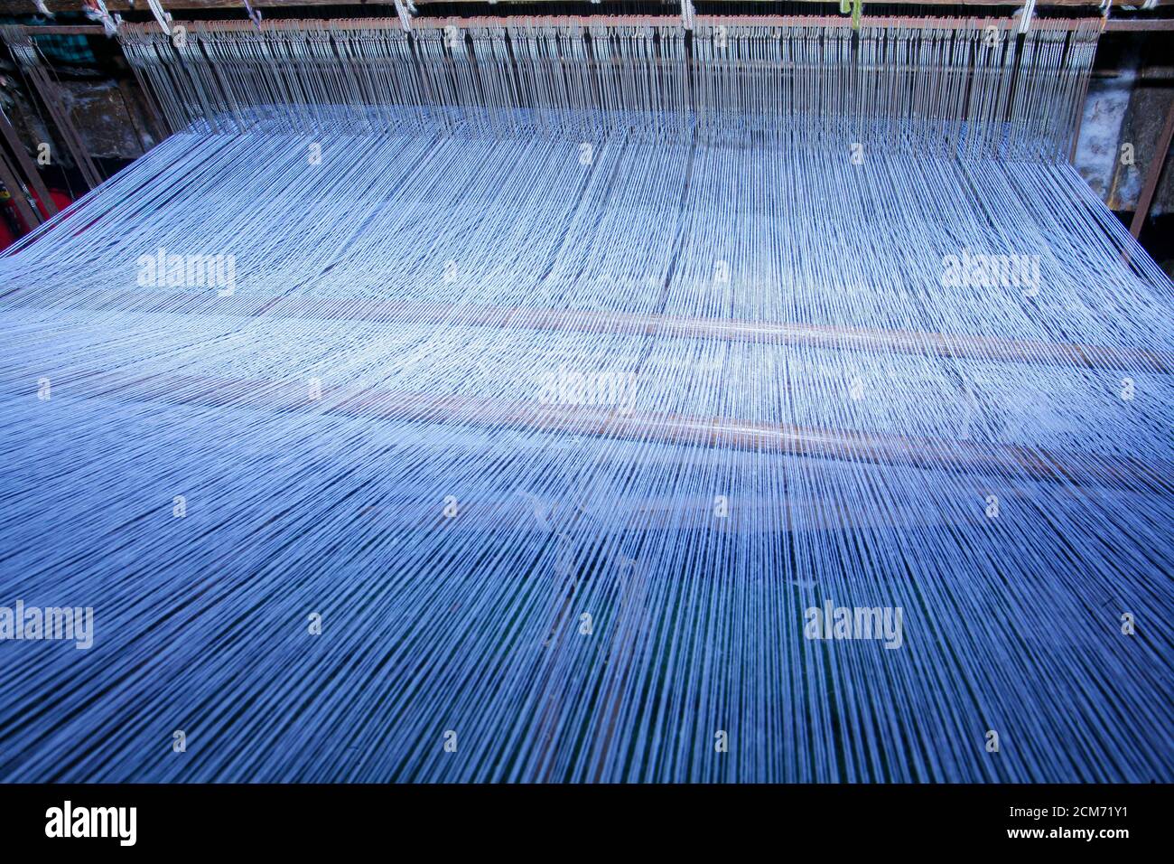 old man weaving Indian hand loom in a traditional old wooden weaving ...