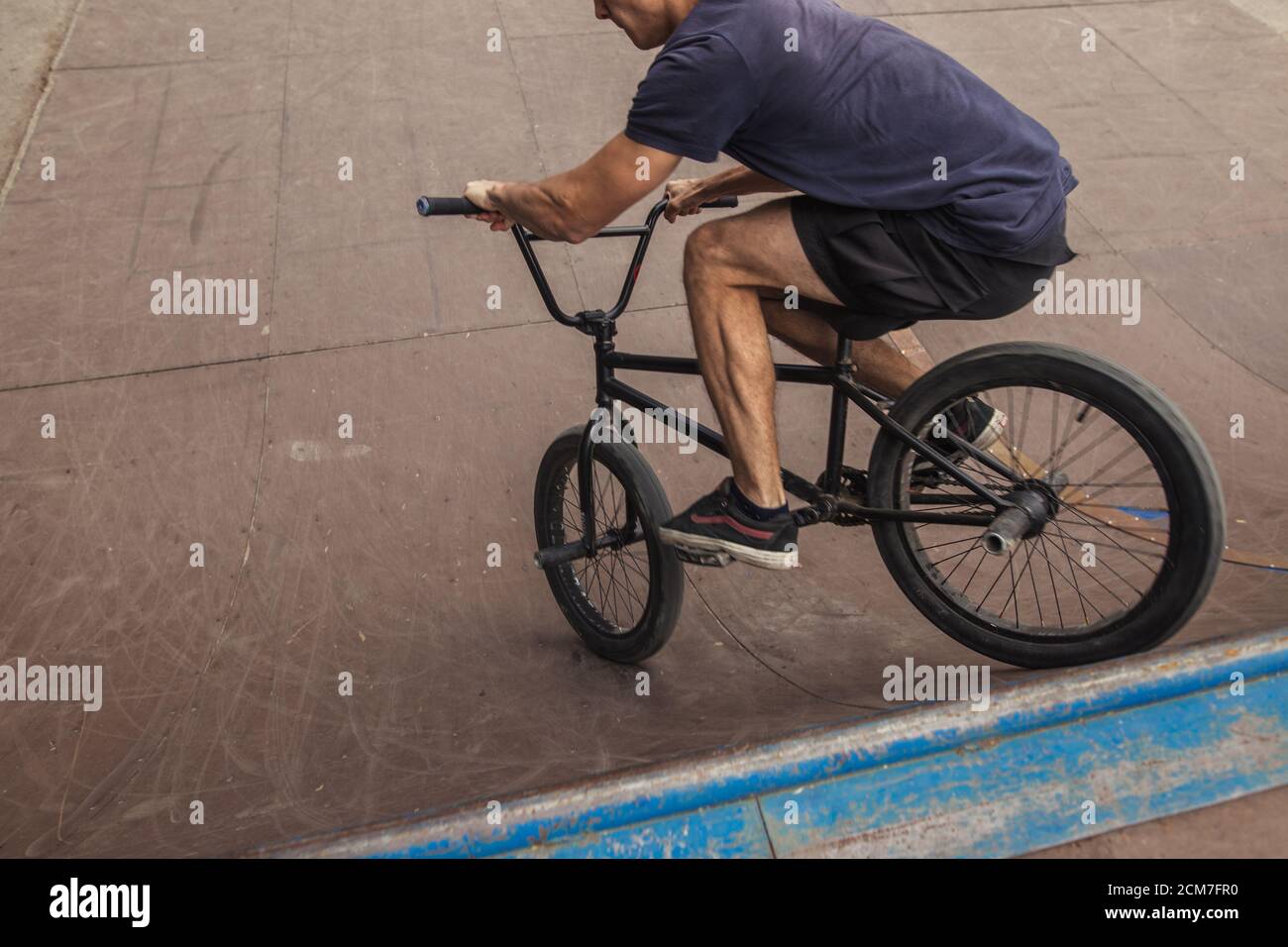 rear back view of Boy riding bmx in a skate park. Beautiful background ...