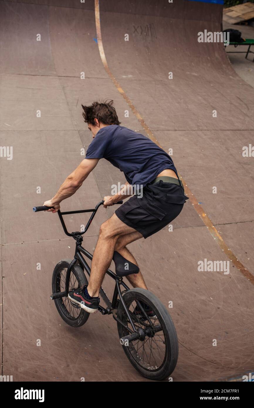 rear view of BMX biker in skate Park in open air, people skills with ...