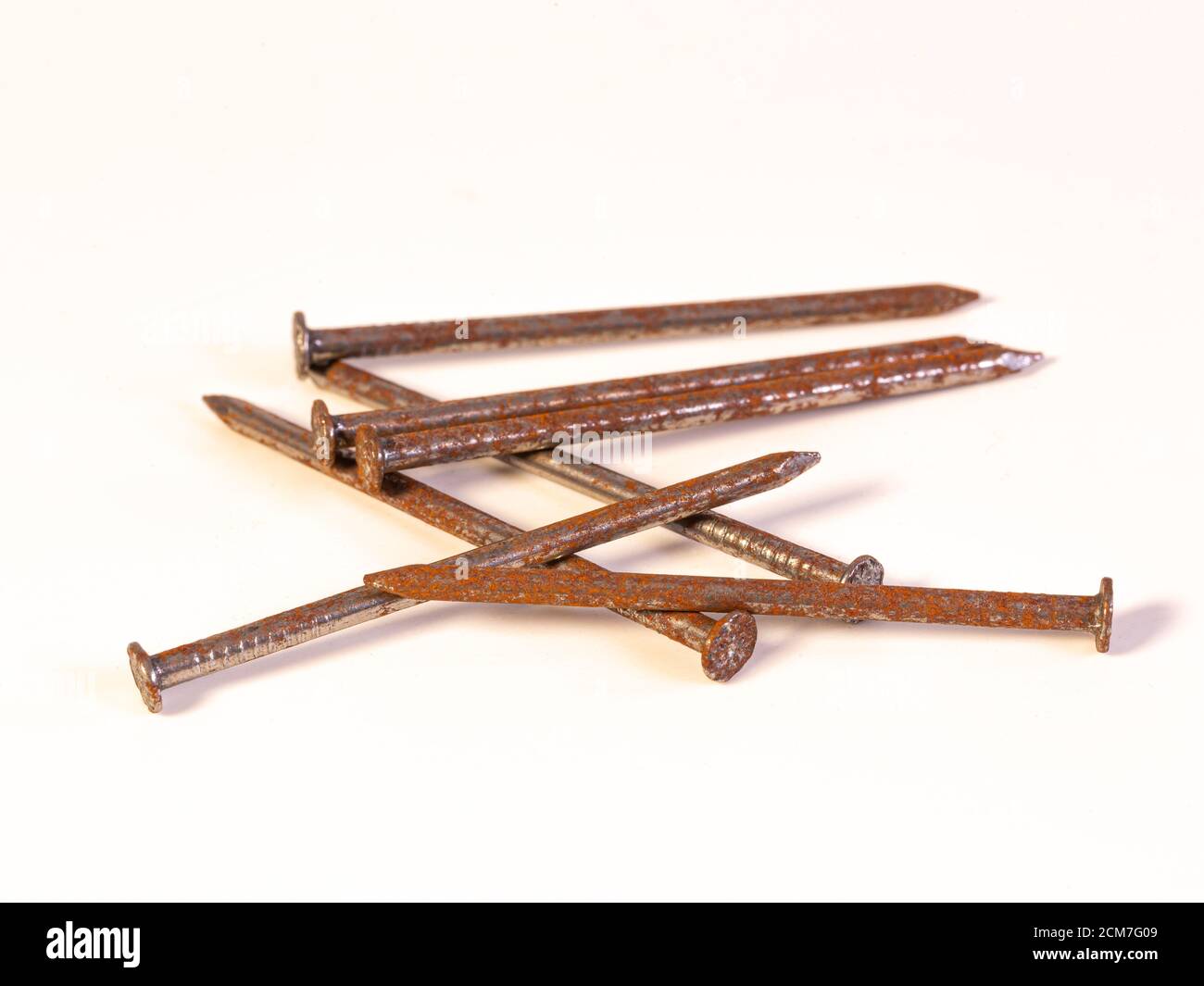 Old and rusty nails lying isolated on white background Stock Photo - Alamy