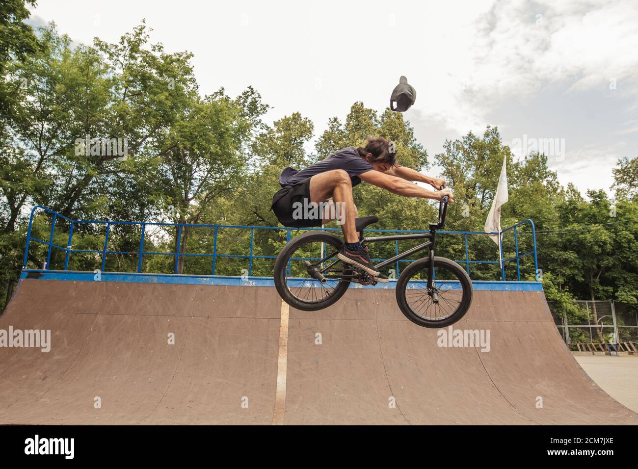 Bmx rider performing jump at ramp on skatepark Stock Photo - Alamy