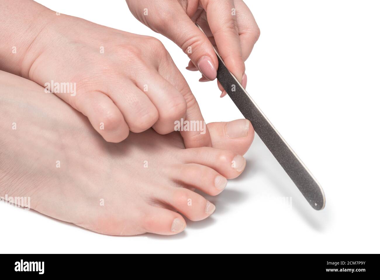 woman with a nail file. cares for toenails. close-up. isolated on white ...