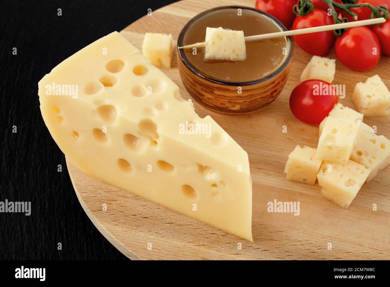 yellow Maasdam cheese, triangular piece cheese with holes, saucer with ...