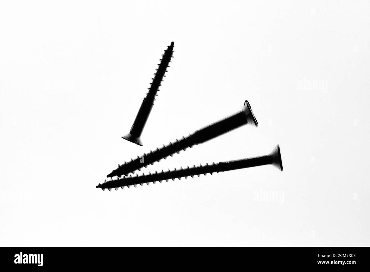 Three screws backlit on white background - copy space Stock Photo - Alamy