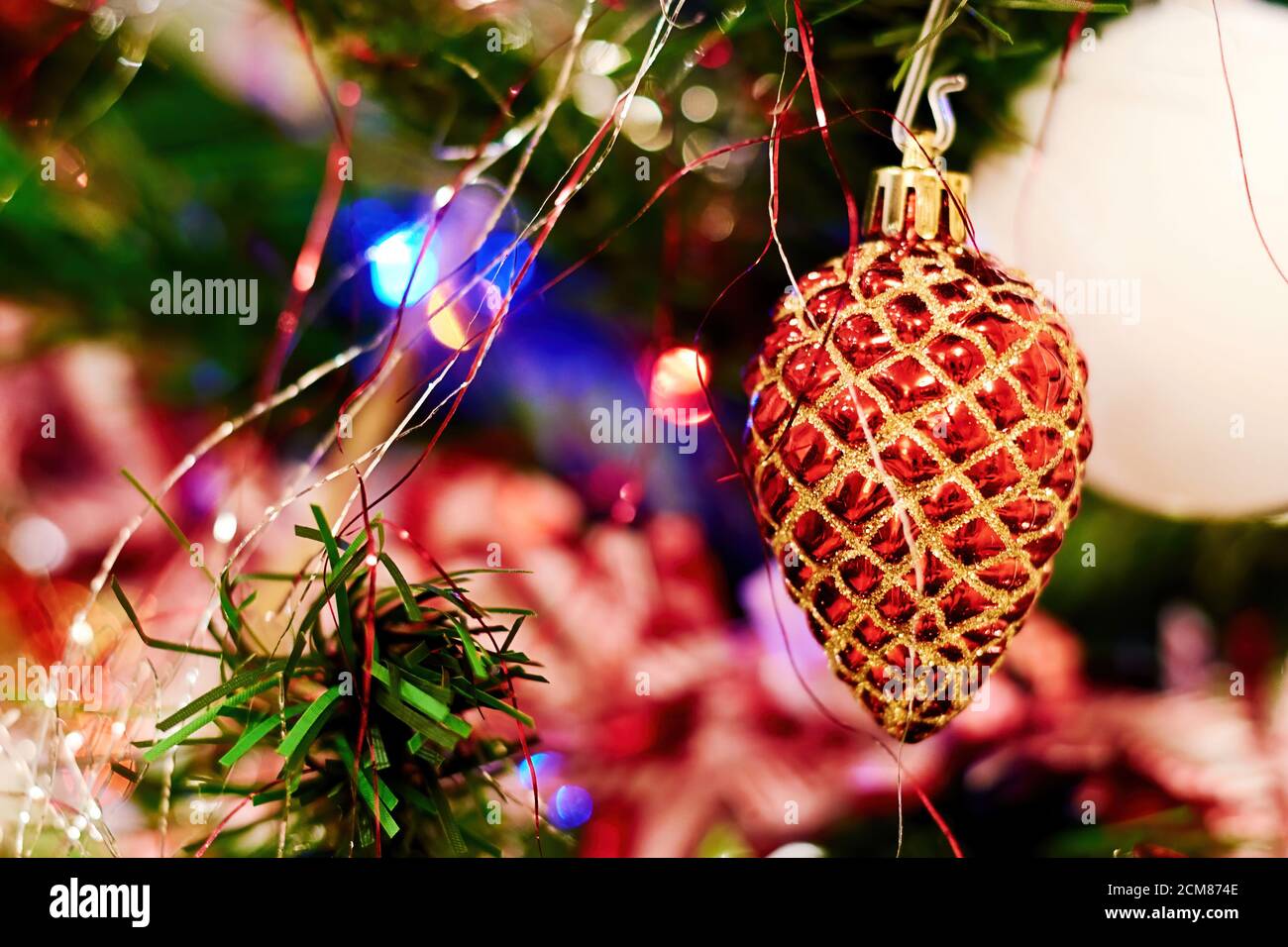 Bright red cone hanging on a branch of a Christmas tree. Festive ...