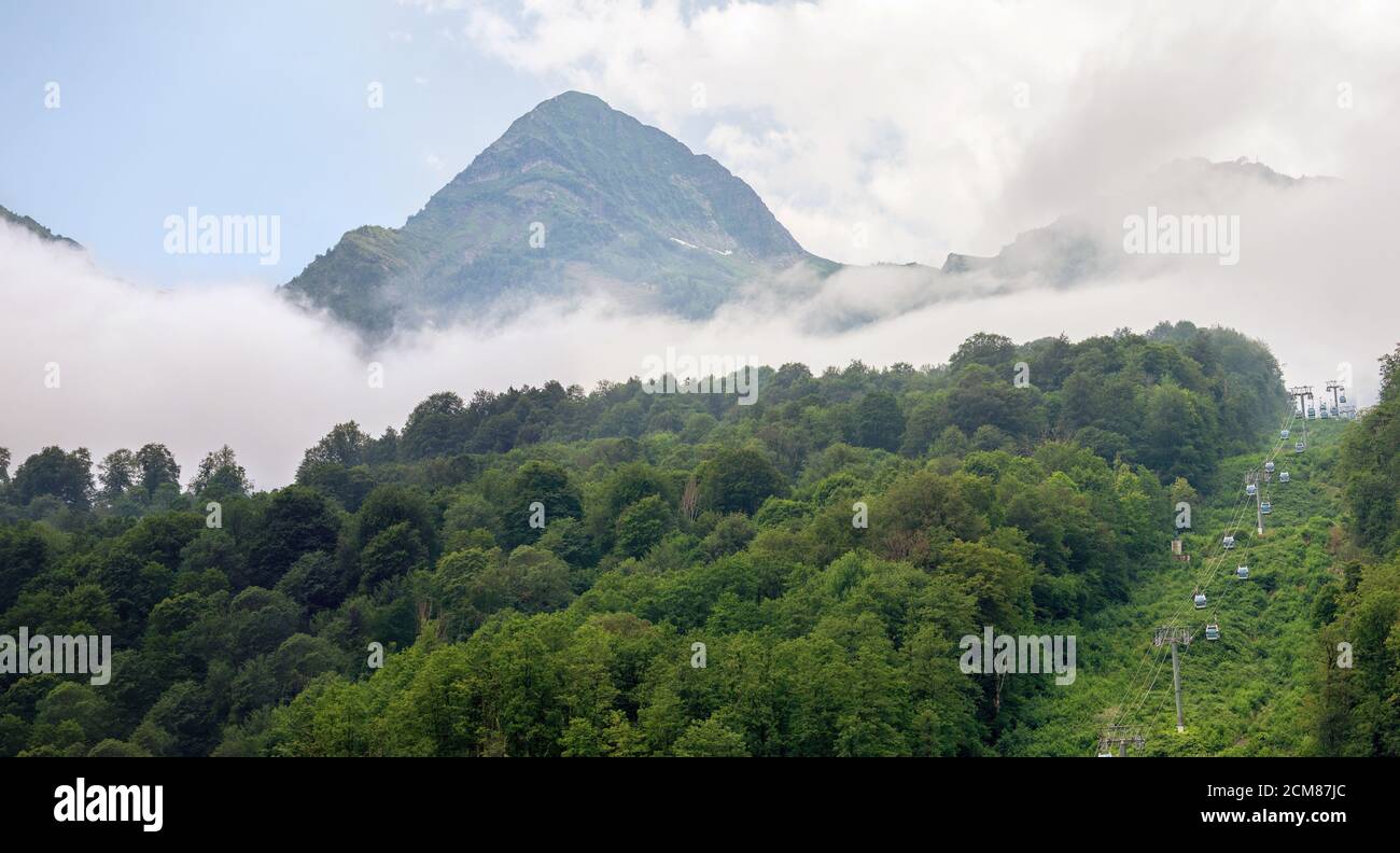 Spectacular panoramic view of green mountains with cable car and peaks ...