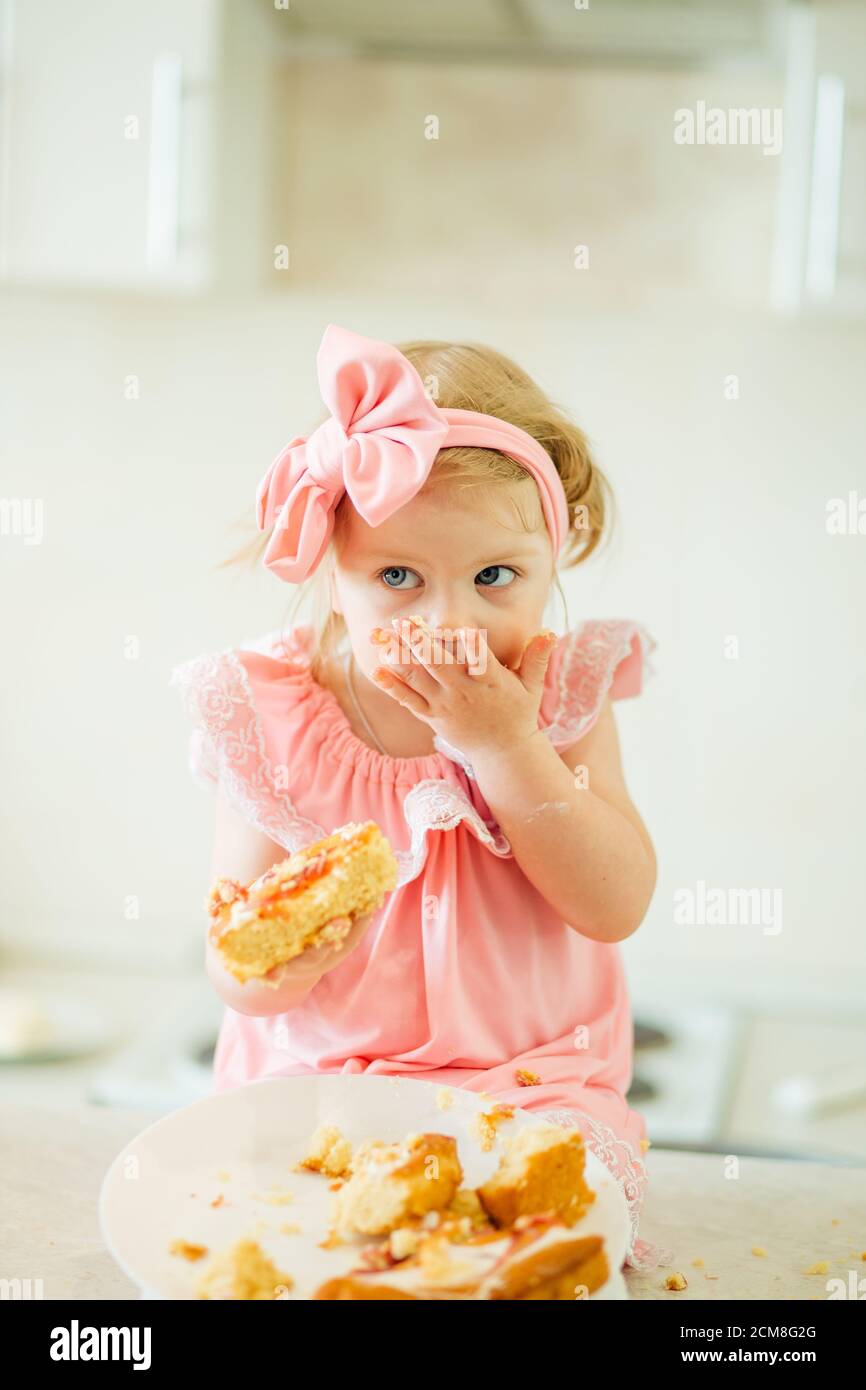 baby girl eat pie at kitchen in home Stock Photo - Alamy