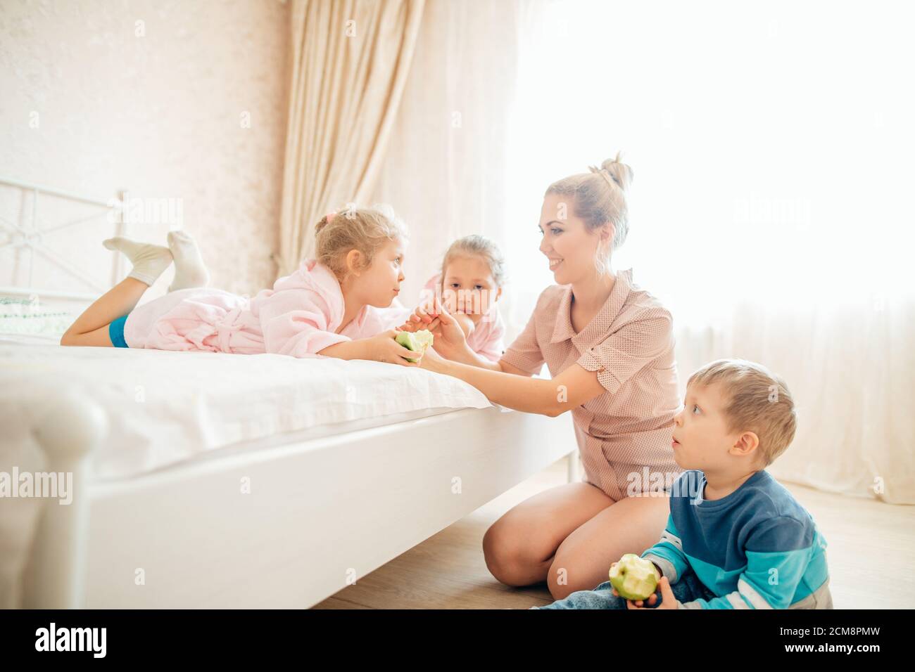 people, family and morning concept - happy child with parents waking up ...