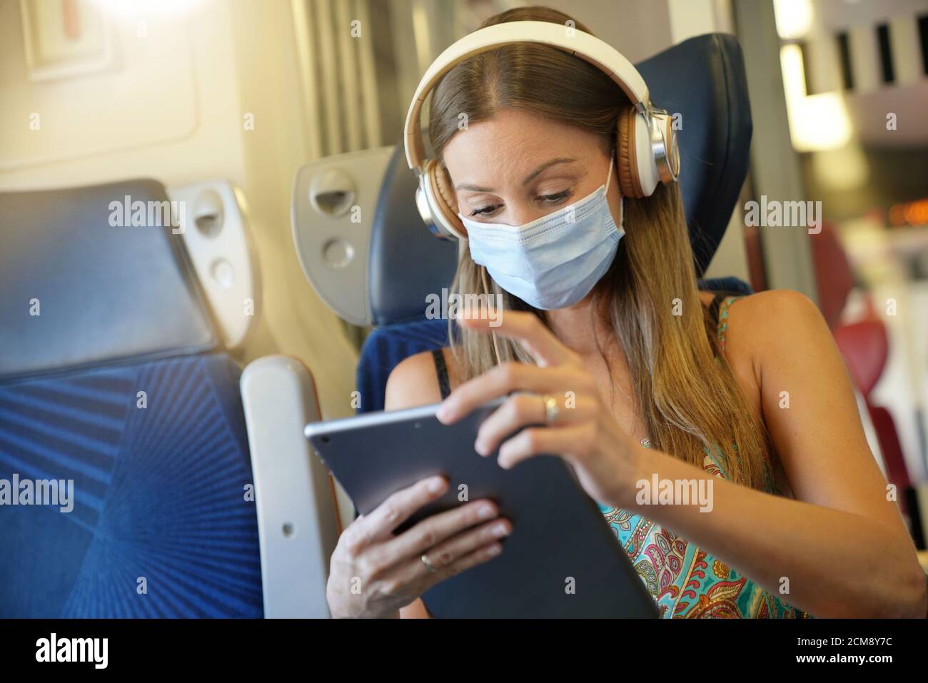 Young woman travelling by train, wearing face mask Stock Photo - Alamy