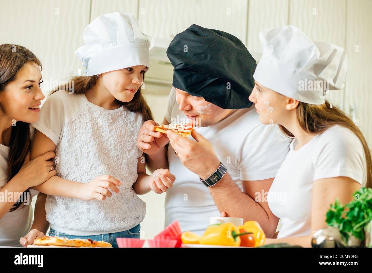Family At Home In Kitchen Making Pizzas Together Stock Photo - Alamy