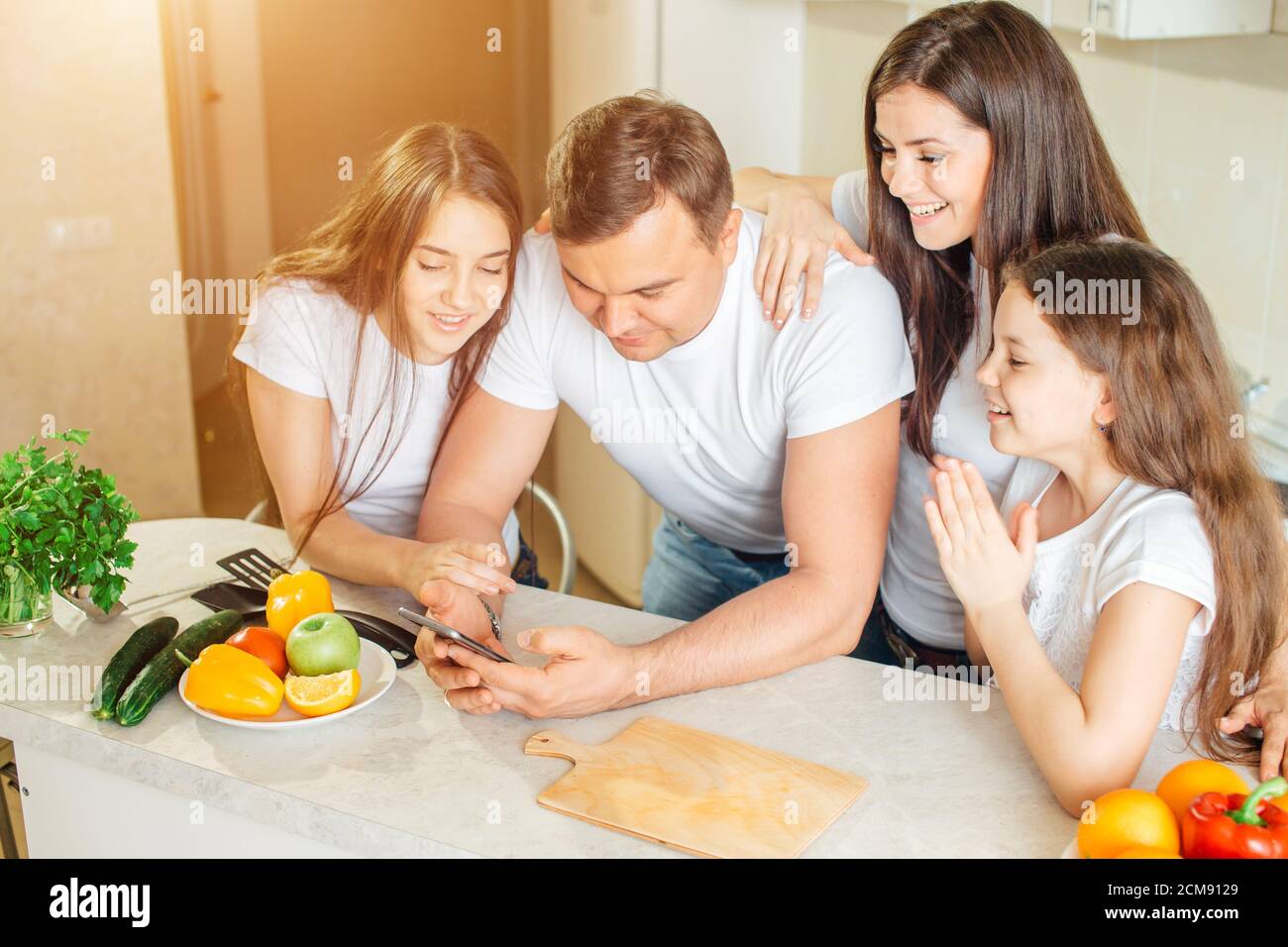 family using cell phone while cooking at kitchen Stock Photo - Alamy