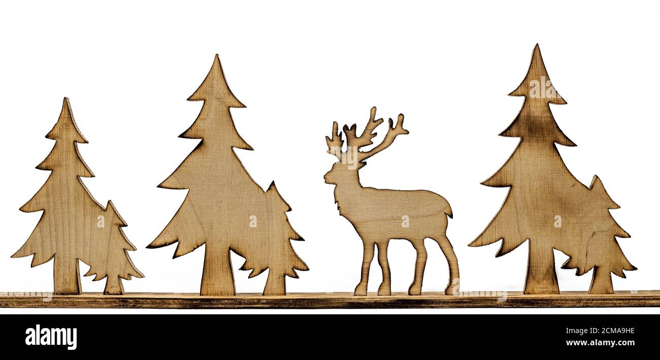 Cut out deer figure made of wood with dark edges and wooden fir trees ...