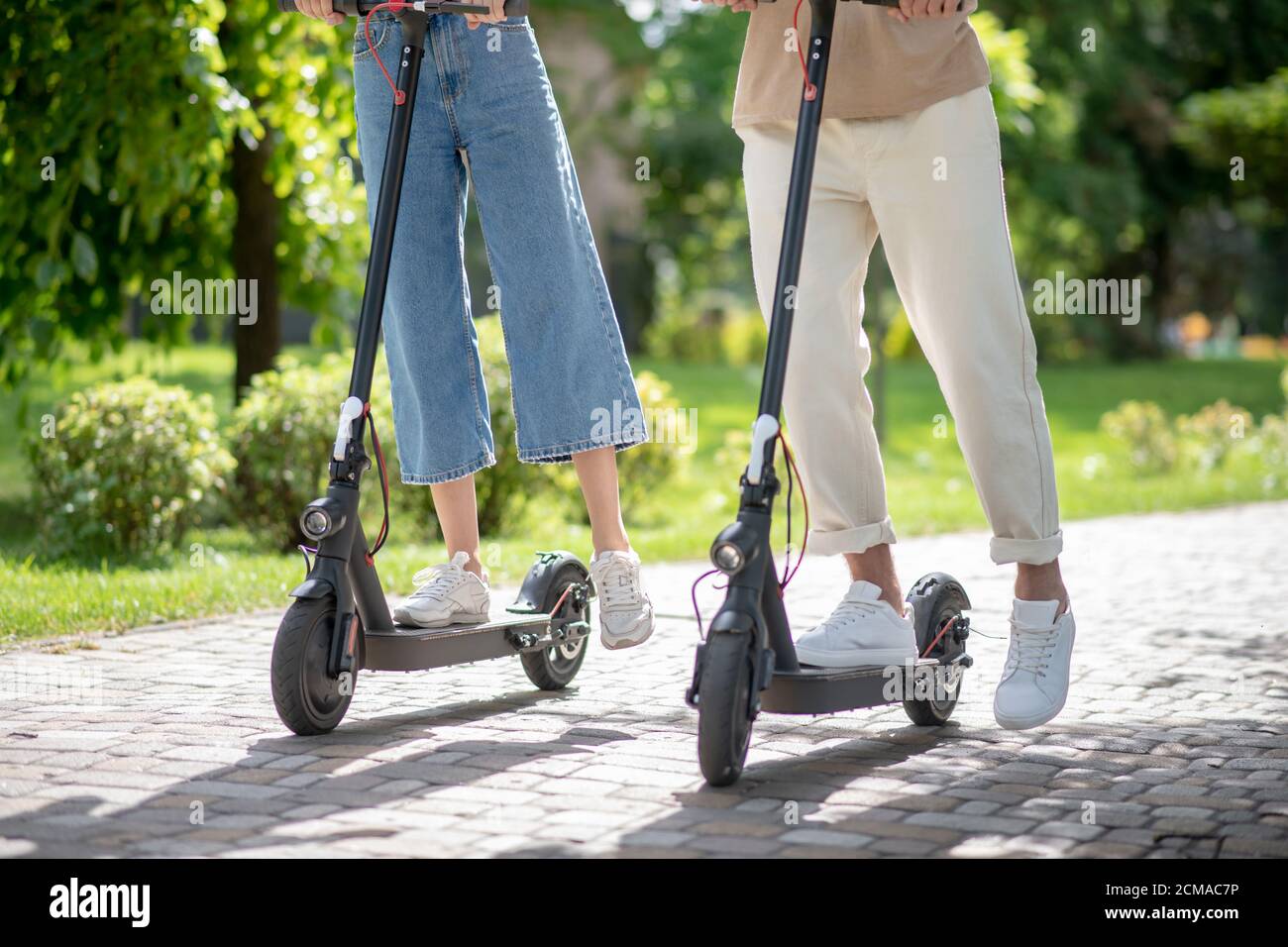 Close up picture of two people riding scooters Stock Photo - Alamy