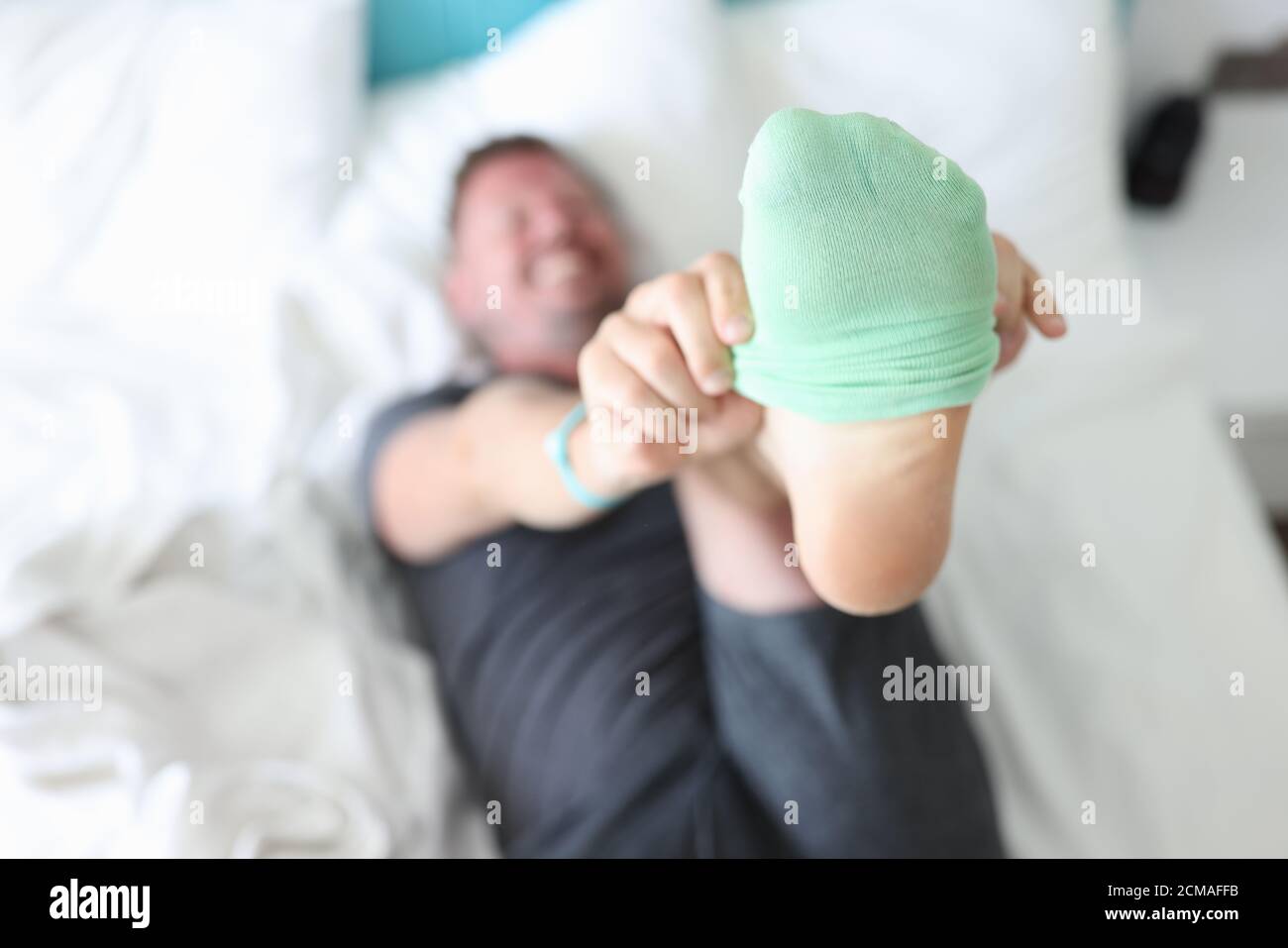 Man try pull sock over his leg Stock Photo - Alamy