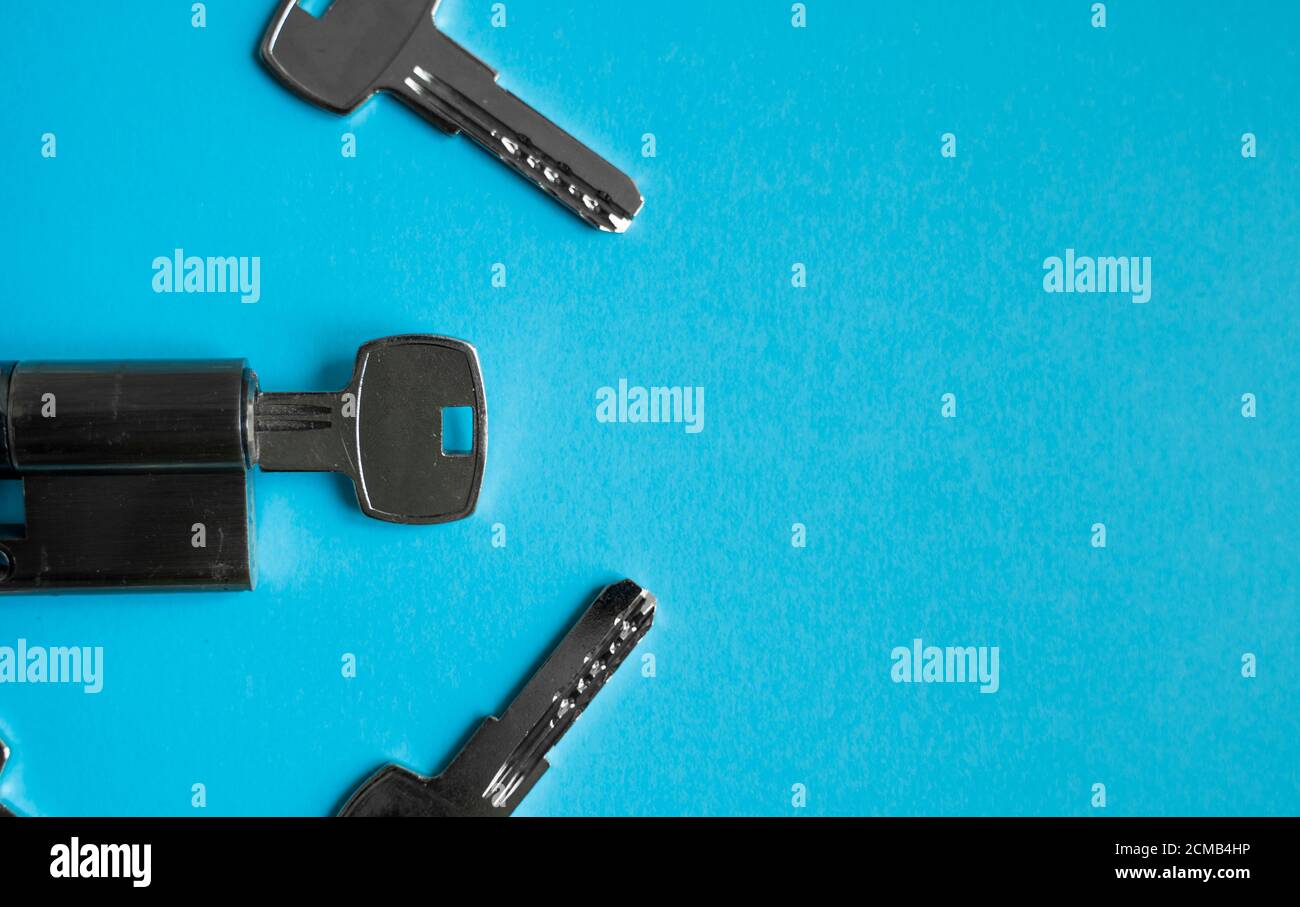 A door lock cylinder core with keys on the blue background. The ...