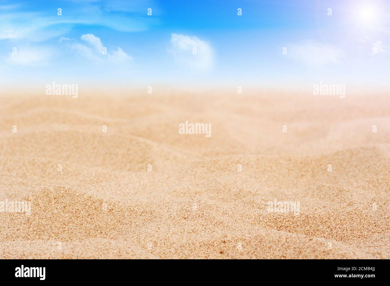 Sand and sky with clouds and sun background Stock Photo - Alamy
