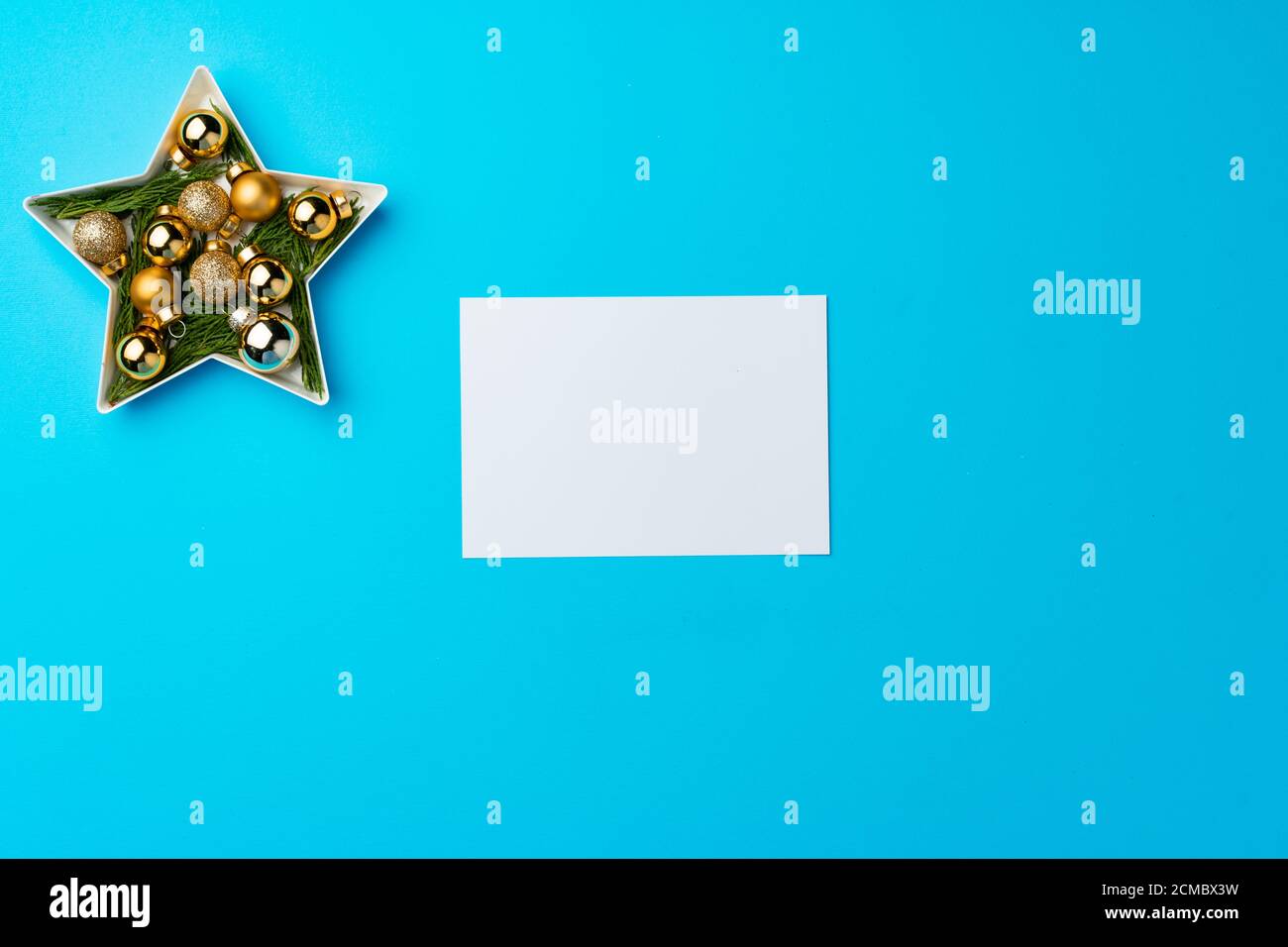 Star shaped plate with golden baubles on blue background Stock Photo ...