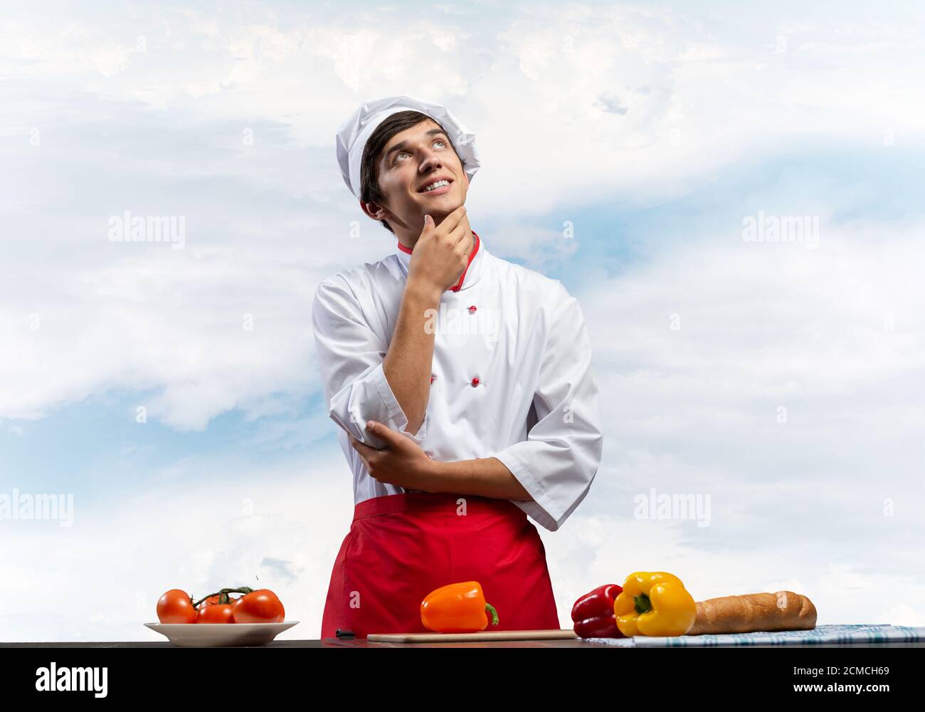 Portrait of a smiling male cook with arms crossed standing in the ...