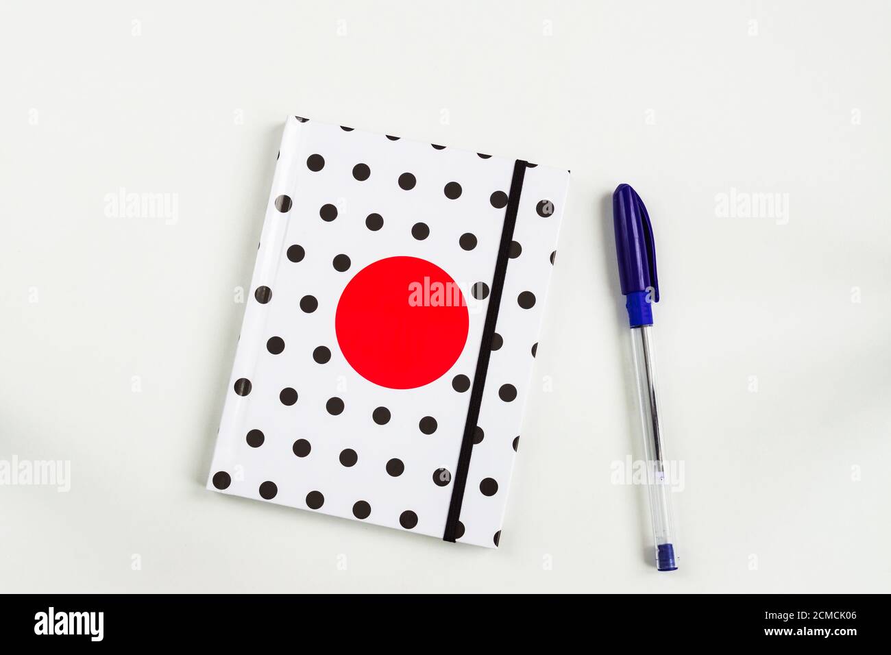 Black and white polka dot note book with red circle on the cover and ...