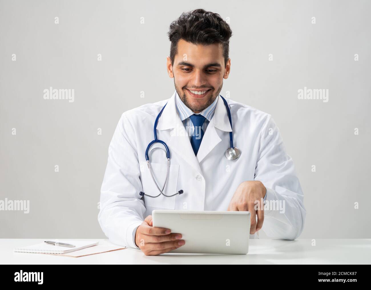 Young smiling internist using tablet computer Stock Photo - Alamy