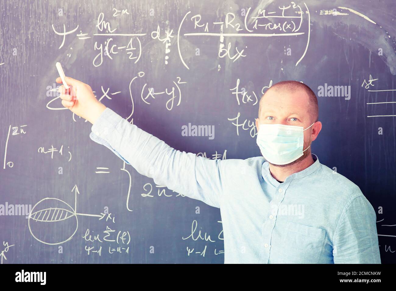 Teacher with mask teaching math lesson at school. Social distanting and ...