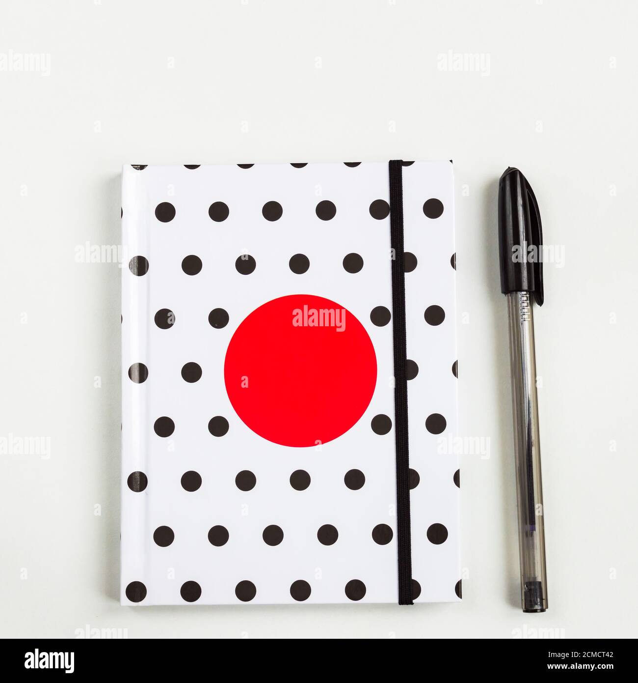 Black and white polka dot note book with red circle on the cover and ...