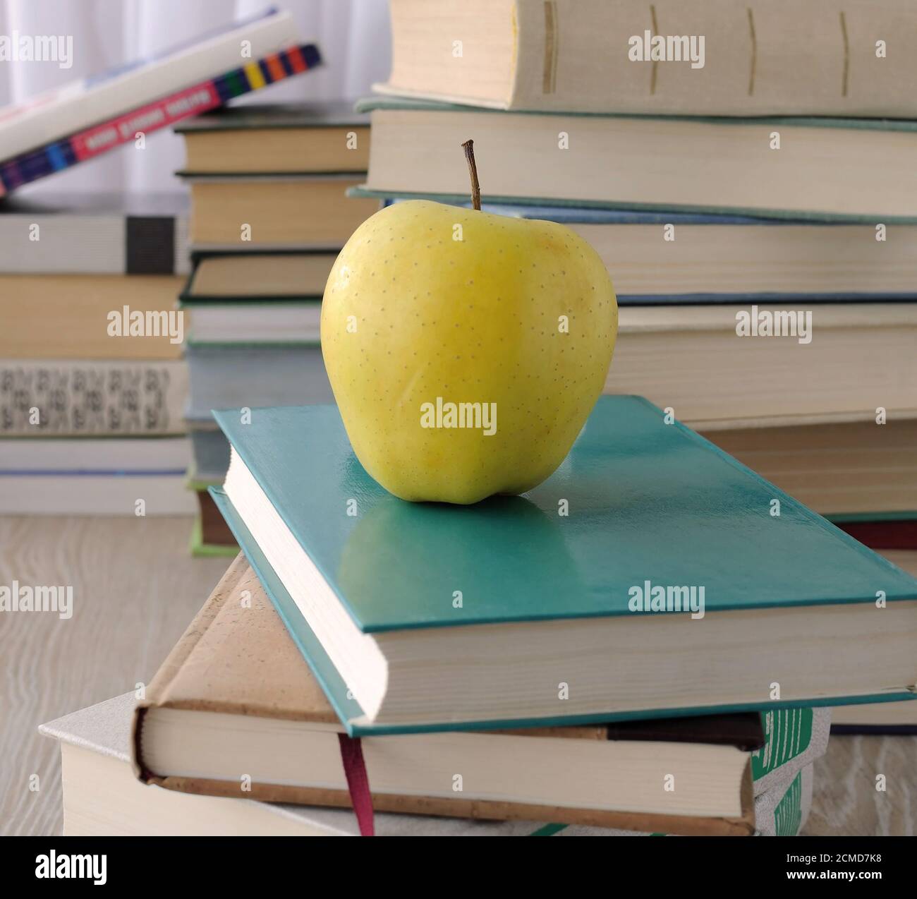 Apple on stack of books Stock Photo - Alamy
