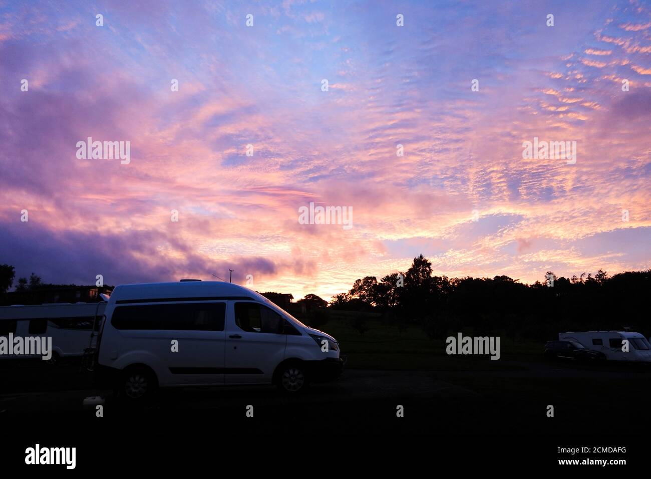 Sunset sky over campsite with campervan Stock Photo - Alamy