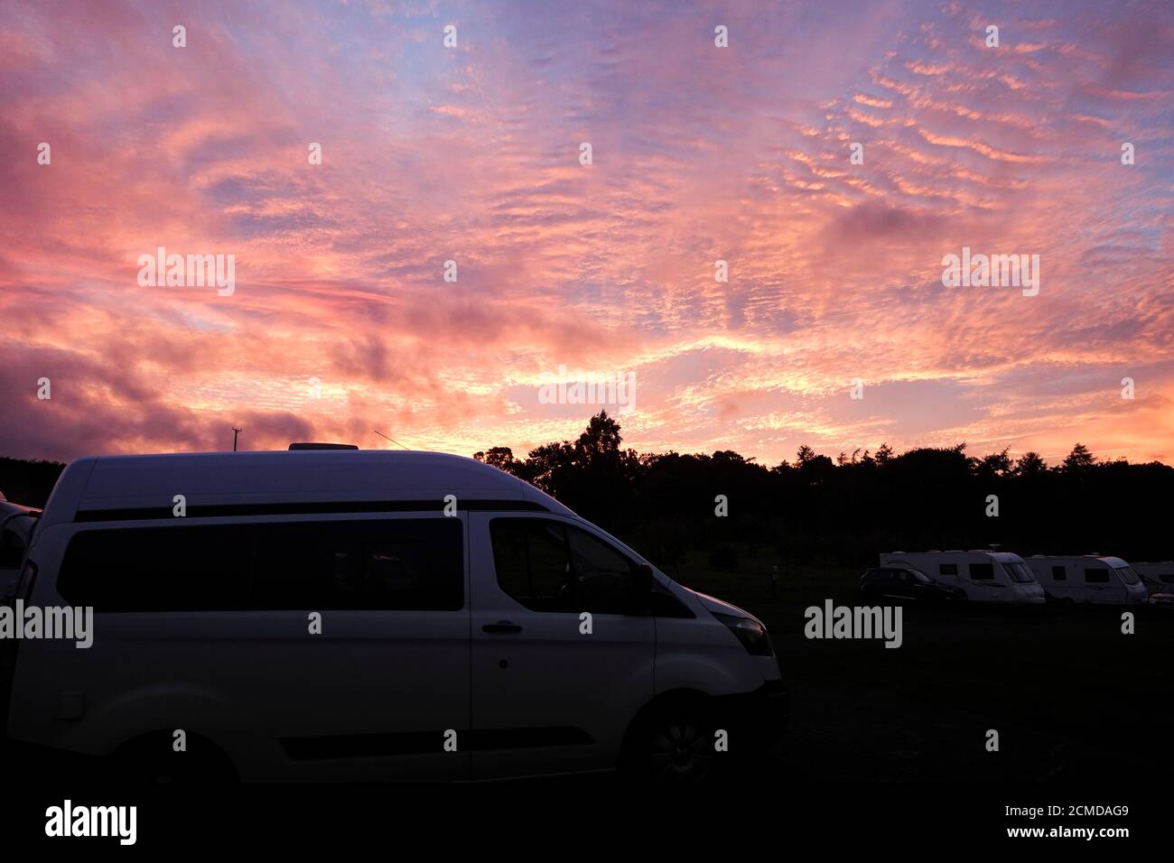 Sunset sky over campsite with campervan Stock Photo - Alamy