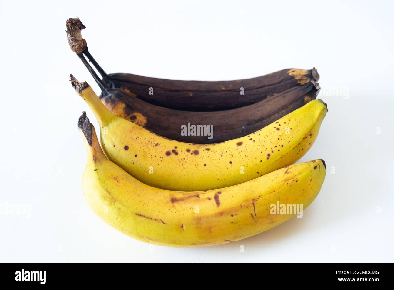 Yellow ripe bananas with two very ripened brown bananas behind, over ...