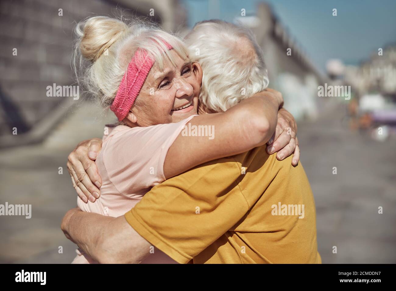 Two elderly people embracing each other outdoors Stock Photo - Alamy