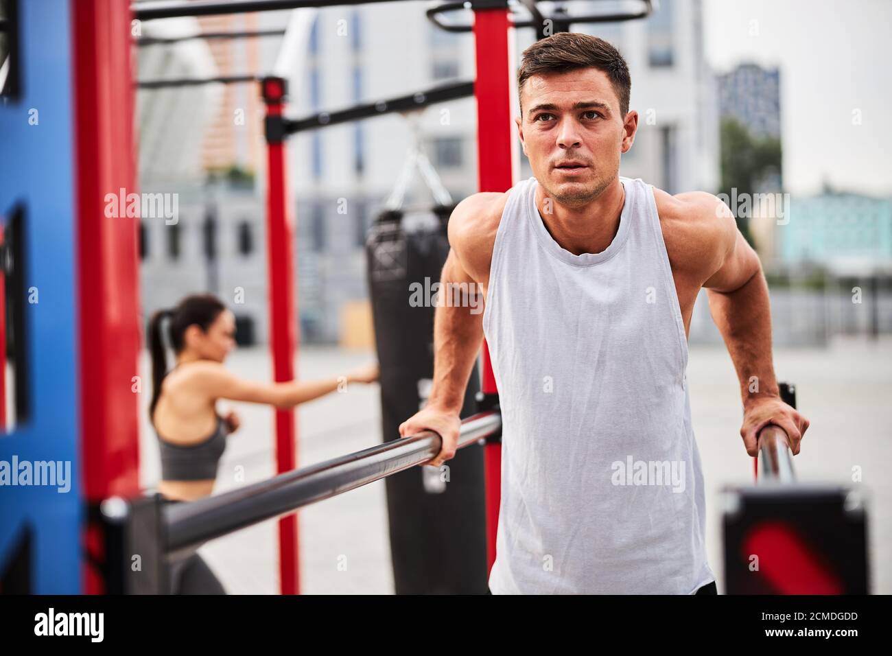Athletic guy training upper body on parallel bars Stock Photo - Alamy