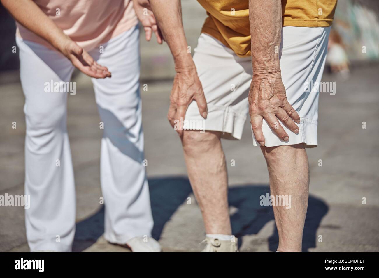 Senior woman touching knees hi-res stock photography and images - Alamy