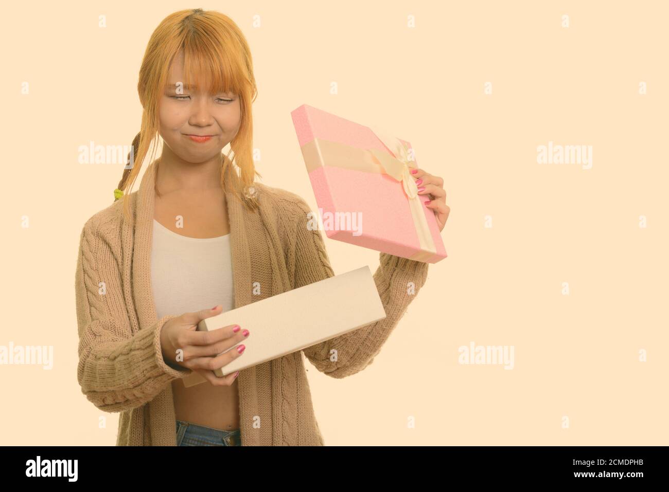 Young cute Asian woman opening gift box looking disappointed Stock ...