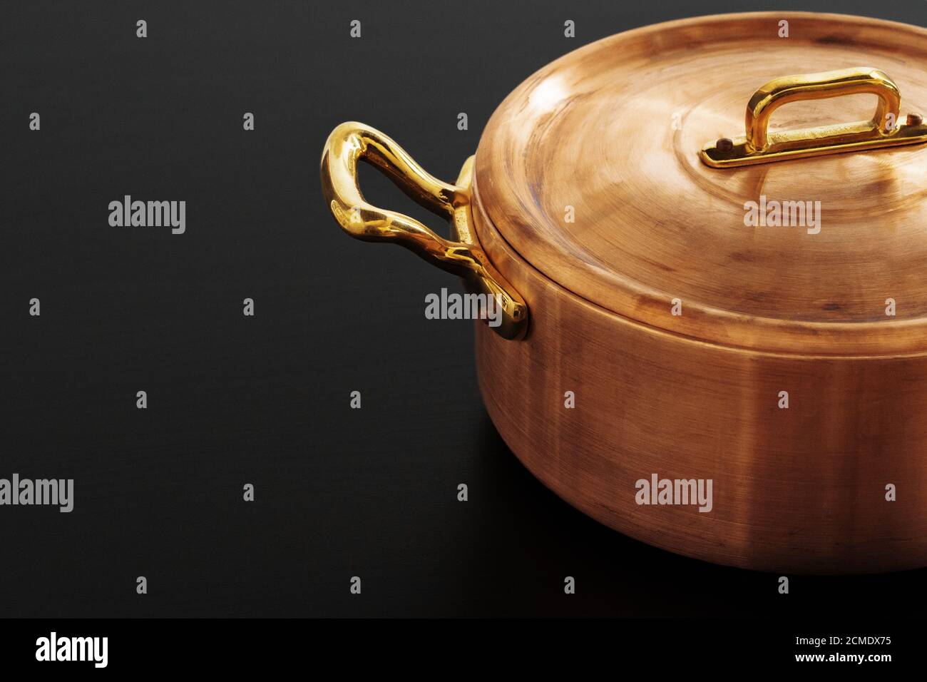 Shiny vintage copper cookware over dark background Stock Photo - Alamy