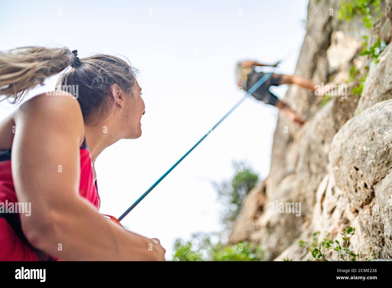 Climber securing another climber going down Stock Photo - Alamy