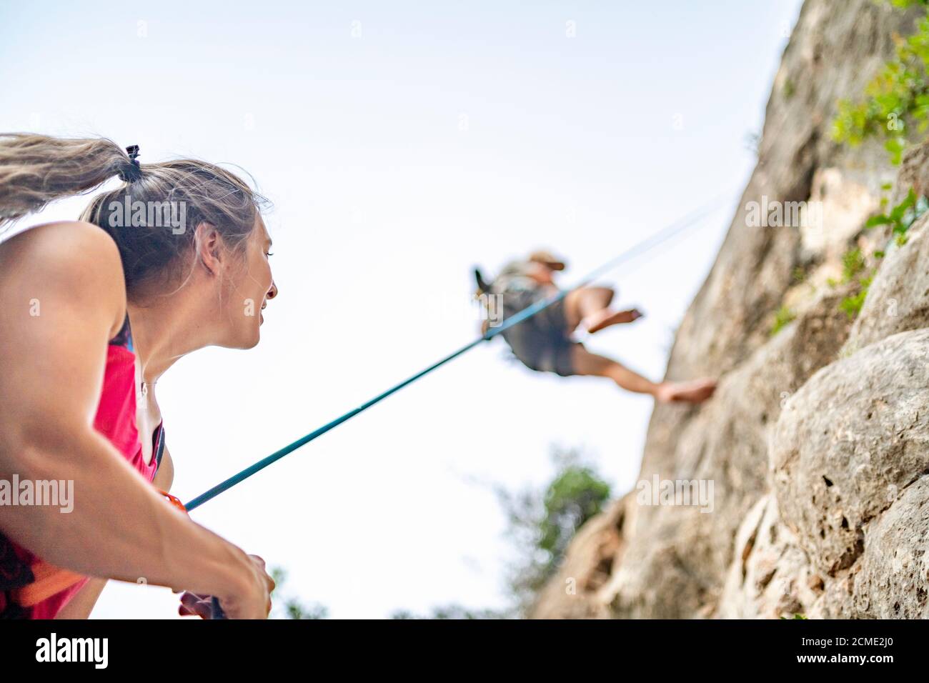 Climber securing another climber going down Stock Photo - Alamy