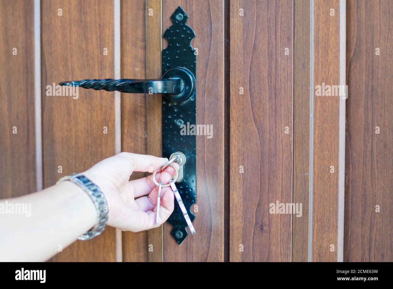human hand opening a wooden door with keys. key handover concept Stock ...