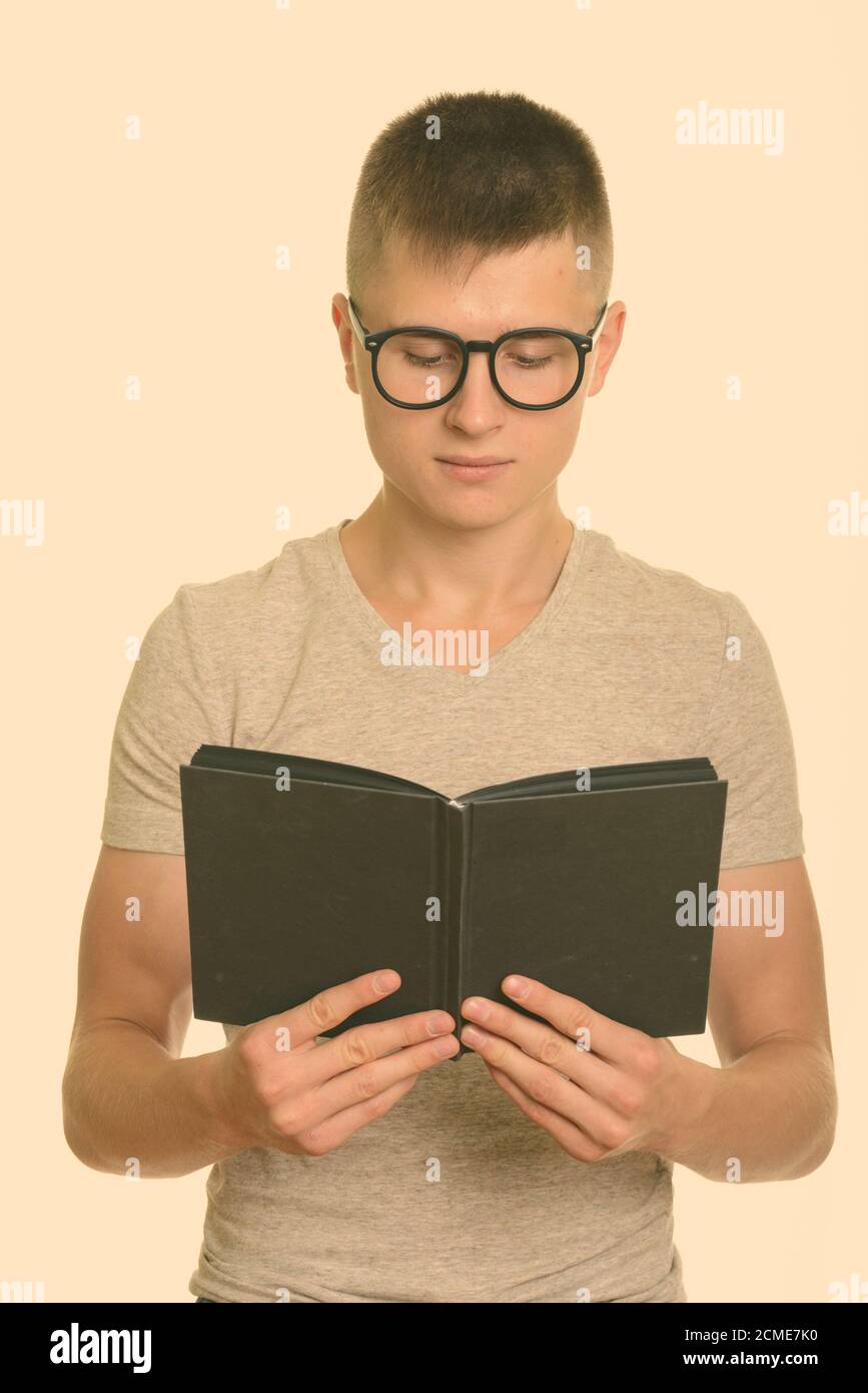 Portrait of young handsome man reading book with eyeglasses Stock Photo ...