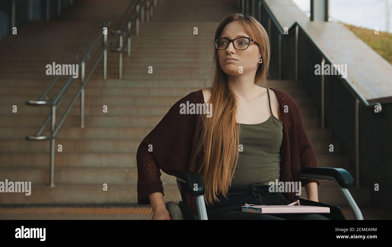 Sad helpless disabled young woman in front of the stairways in the ...