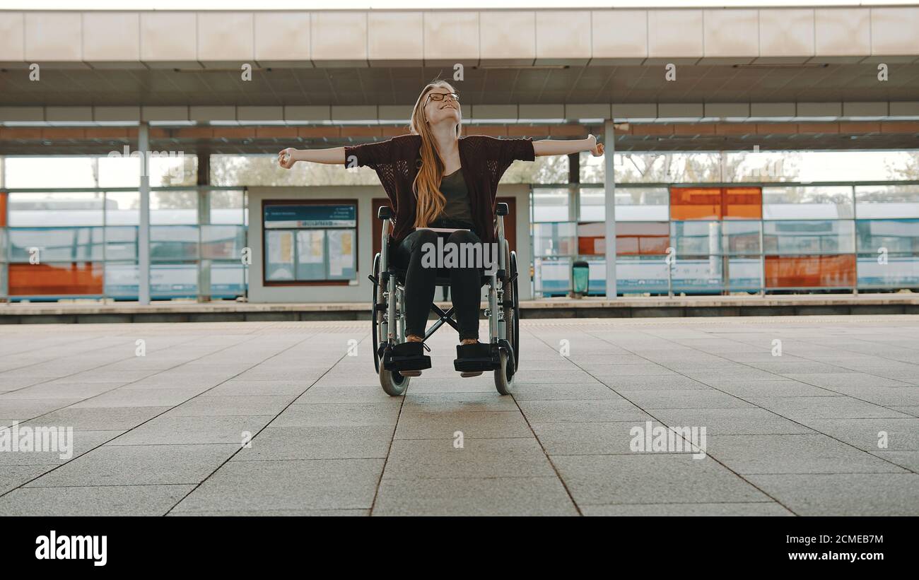Happy young independent disabled woman on the train station. High ...