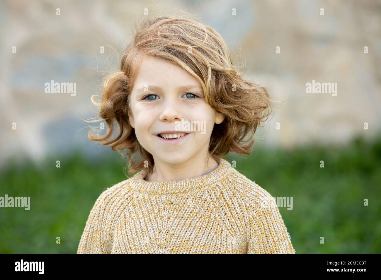 Funny blond kid with long hair Stock Photo - Alamy